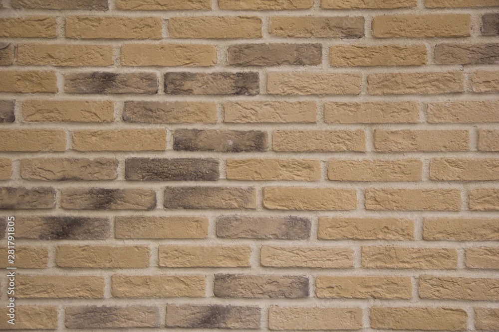 light brown stone brick exterior wall in hard light emphasizing stone's ...