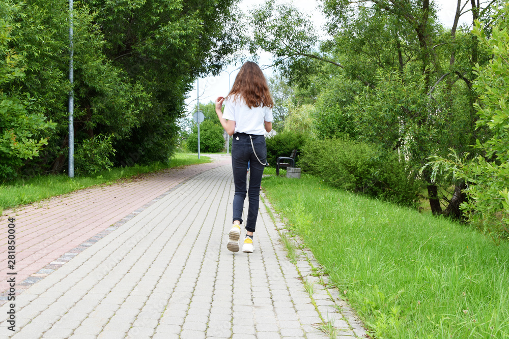 Teenage girl with long brown hair wearing black jeans with chain and ...