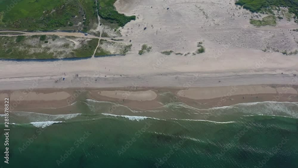 The cold waters of the Atlantic Ocean bathe a scenic beach on Cape Cod ...