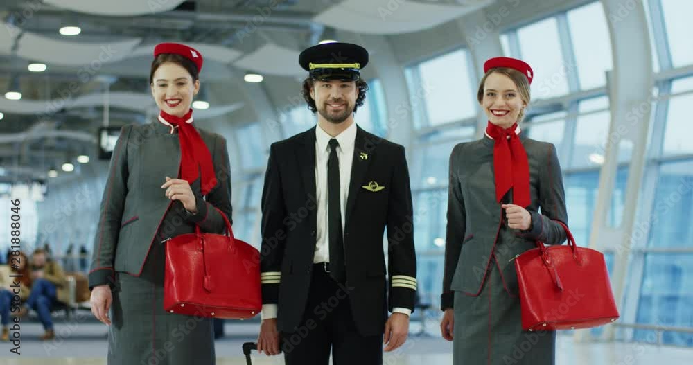 Portrait shot of the handsome male young Caucasian pilot and two pretty ...
