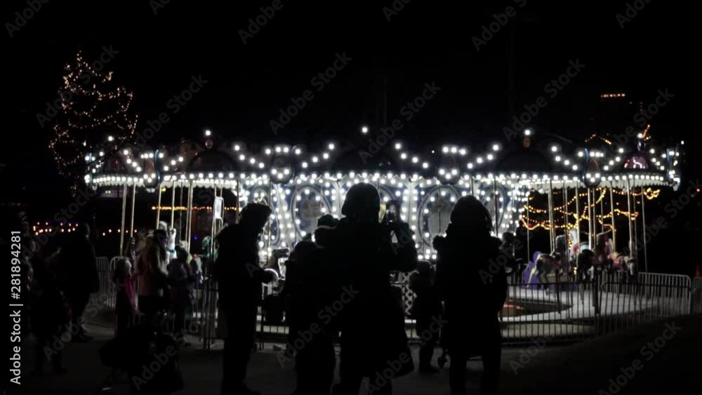 Brightly lit flashing light vintage carousel at winter light festival ...