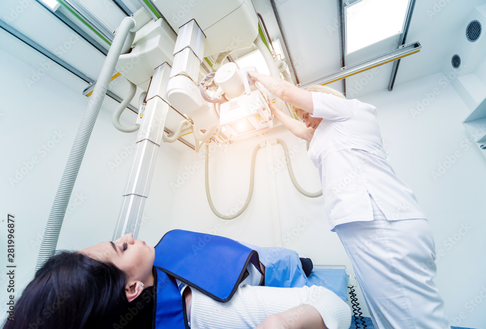 Radiologist and patient in a x-ray room. Classic ceiling-mounted x-ray ...