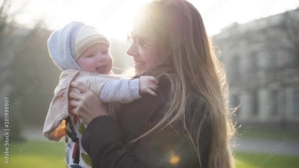 A middle plan of a young woman jumping with her yearling daughter in a ...