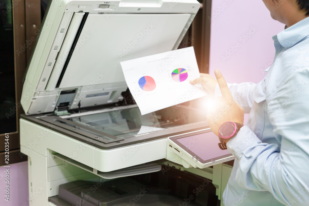 Men press the button of the copier. Man copying paper from Photocopier ...