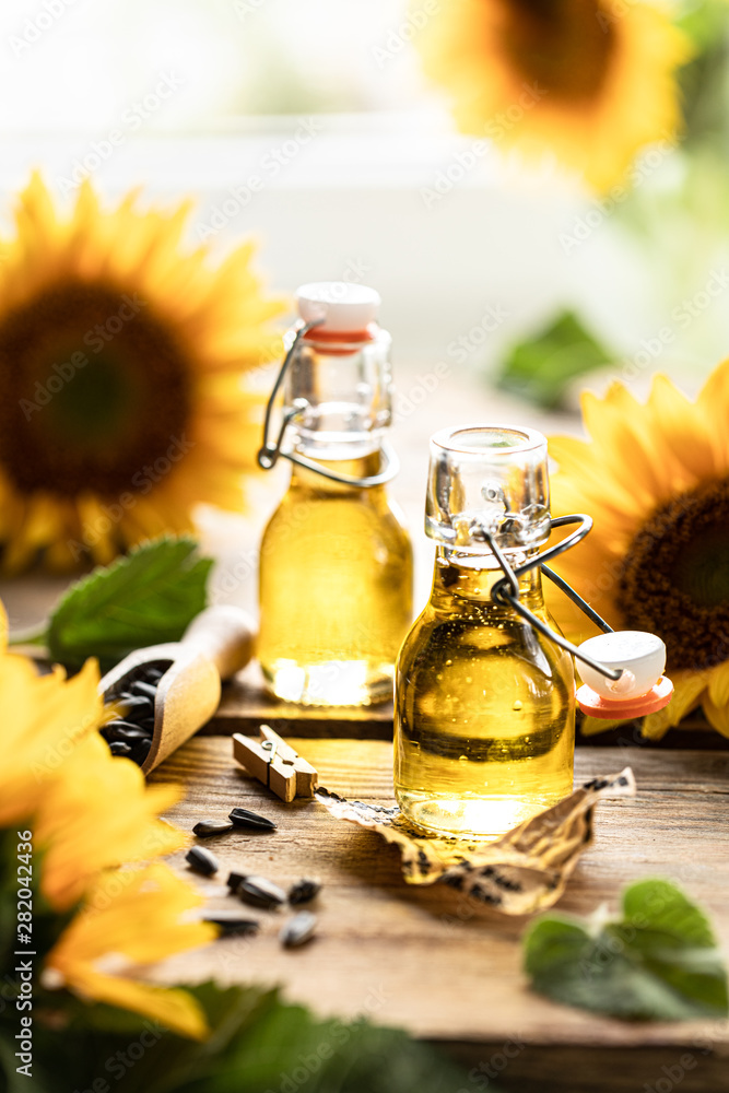 Sunflower oil in a bottle glass with seeds and flowers of sunflower. on ...
