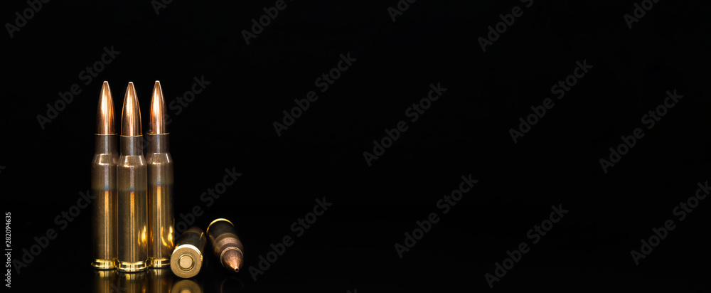 Bullet isolated on black background with reflexion. Rifle bullets close ...