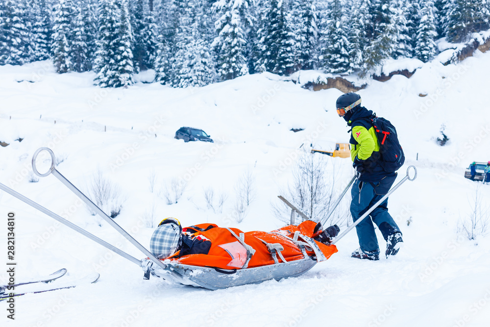 Ski rescue team with slide stretcher, brings help to ski during bad ...