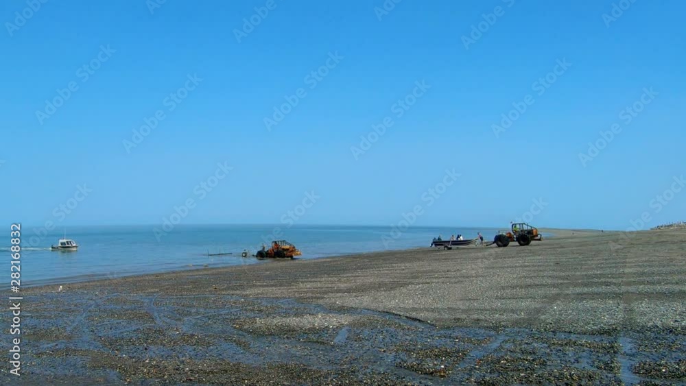 Vidéo Stock Two tractors on beach; in background tractor towing a ...