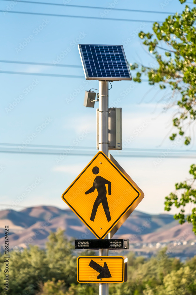 Pedestrian Crossing sign and Diagonal Arrow sign against mountain and ...