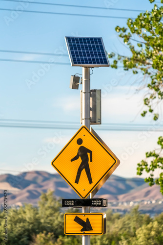 Pedestrian Crossing sign and Diagonal Arrow sign against mountain and ...
