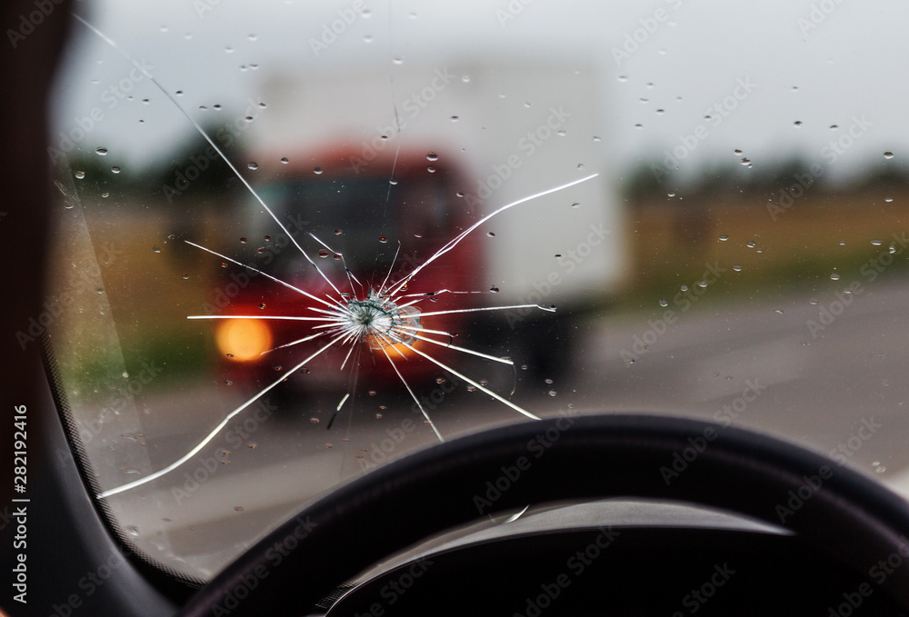 Broken windshield of a car. A web of radial splits, cracks on the ...
