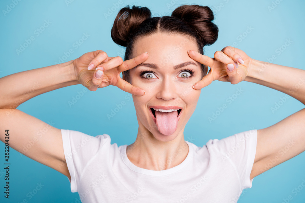 Funny lady showing v-sign symbol near eyes sticking tongue out mouth ...