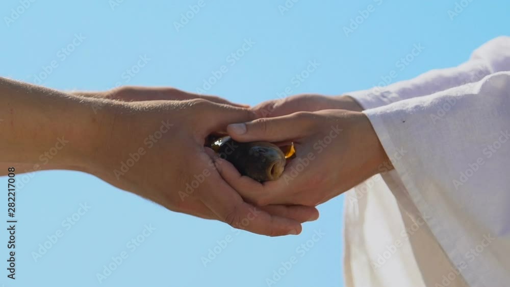Jesus Christ giving fish to poor person starving from hanger, hands ...