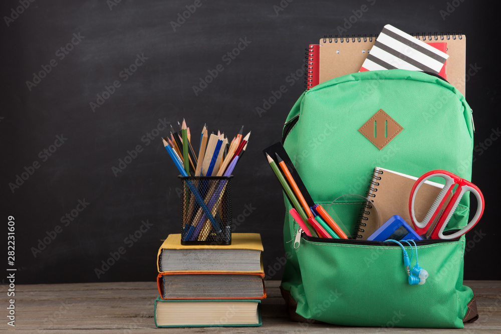 Education concept - school backpack with books and other supplies ...