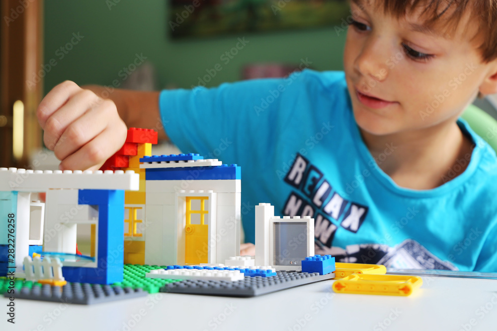 Boy builds a house with building blocks Stock Photo | Adobe Stock