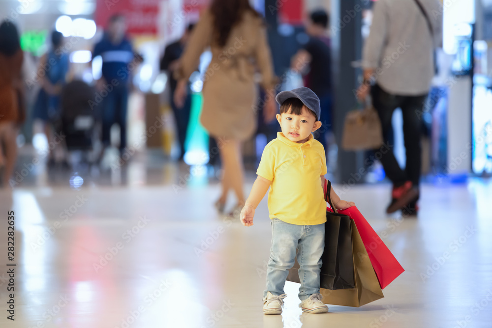 Kid shopping. Asian little boy in yellow shirt and jeans enjoyment of ...