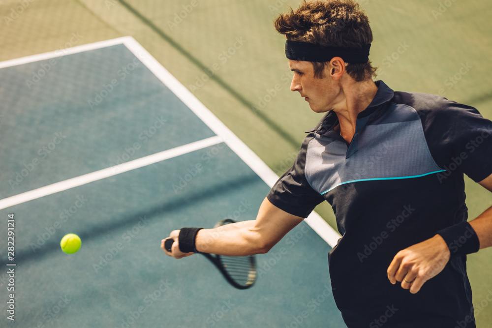 Professional tennis player hitting forehand Stock Photo | Adobe Stock
