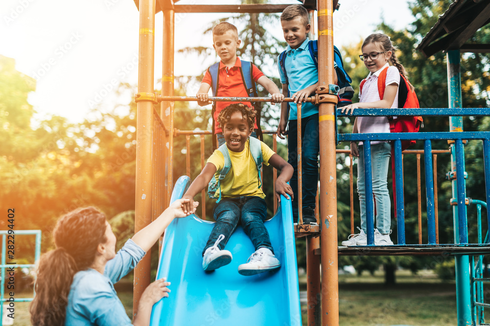 School children playing on the slide. Stock Photo | Adobe Stock