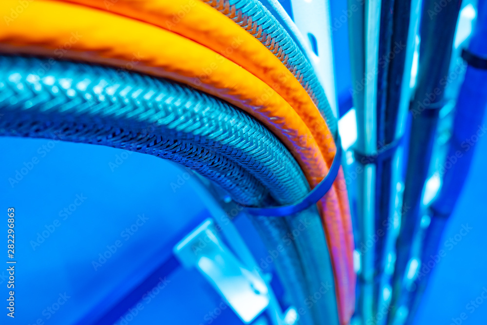 Blue and orange cables on the wall. Wires secured with plastic tie ...