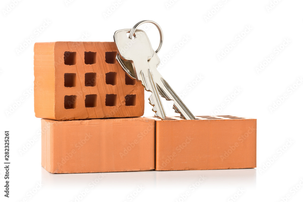 House keys on bricks over white background - home owner, real estate or ...