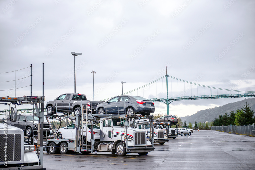 Big rigs car haulers semi trucks with loaded cars standing in row on ...