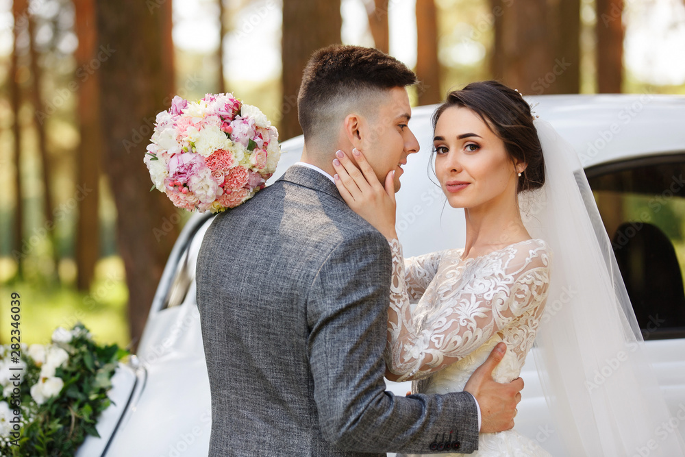 Wedding couple posing near white Wedding car. Just married car for the ...
