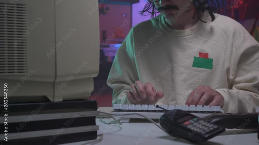 In the '80s or '90s young man using his personal computer typing on a ...