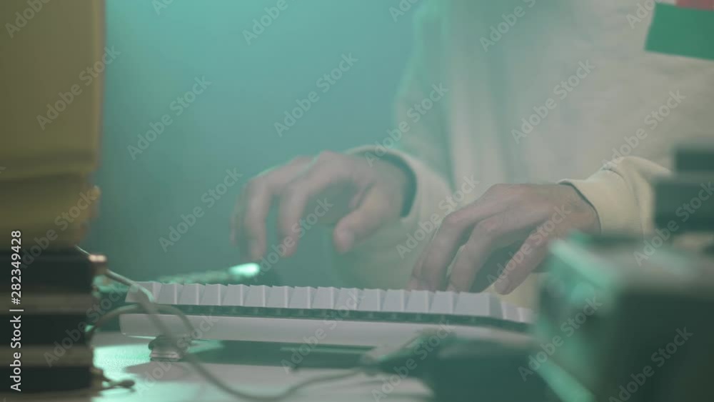 In the '80s or '90s young man using his personal computer typing on a ...