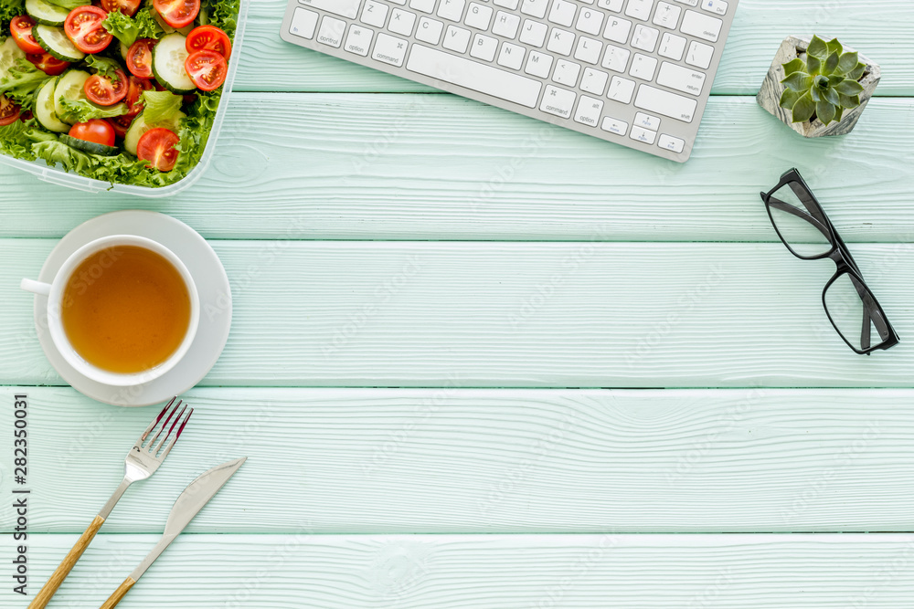 meal in lunch box and tea for dinner on mint green office desk ...