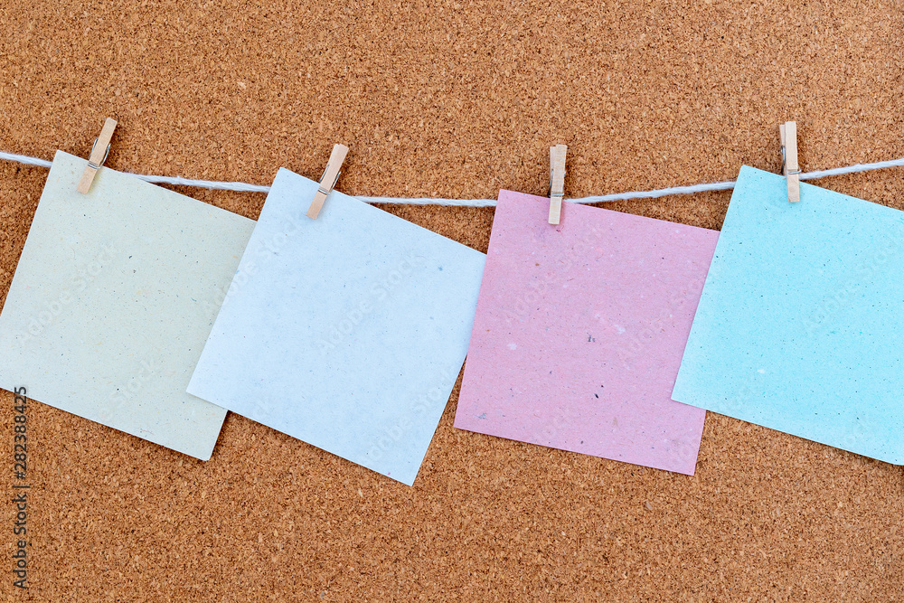 Corkboard with different color stickers fixed by a pin. Square shaped ...