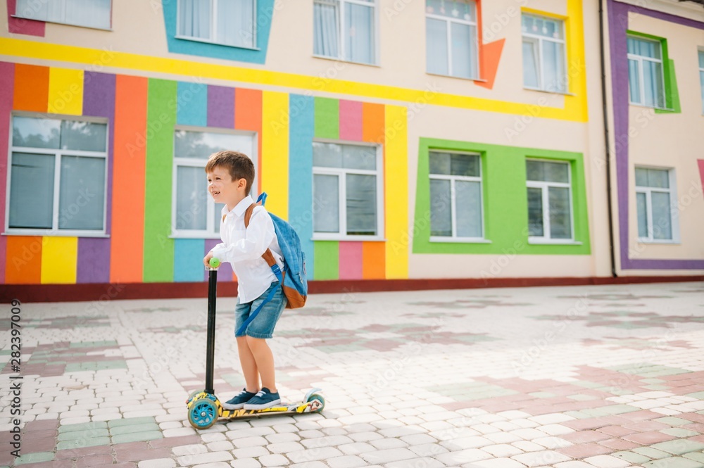 Boy goes to school on a scooter. Children back to school scoote ...