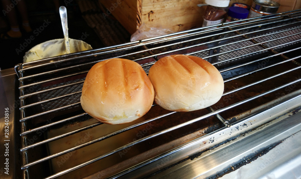 Stainless steel grill with bread buns toasted on a grill.Toasted butter ...