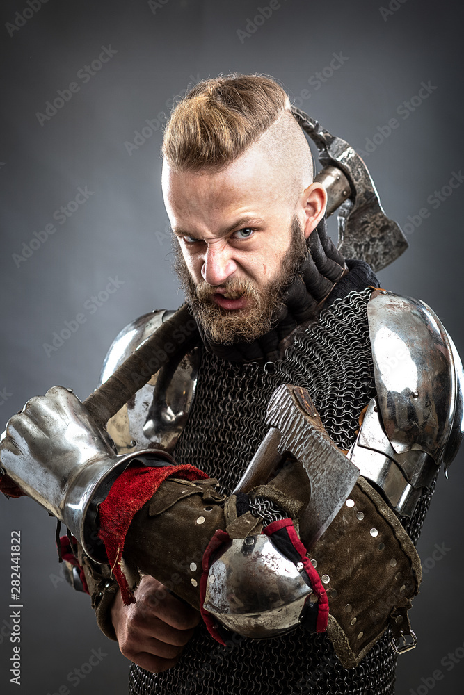 A fierce warrior standing in a battle-ready stance, holding a pair of ...