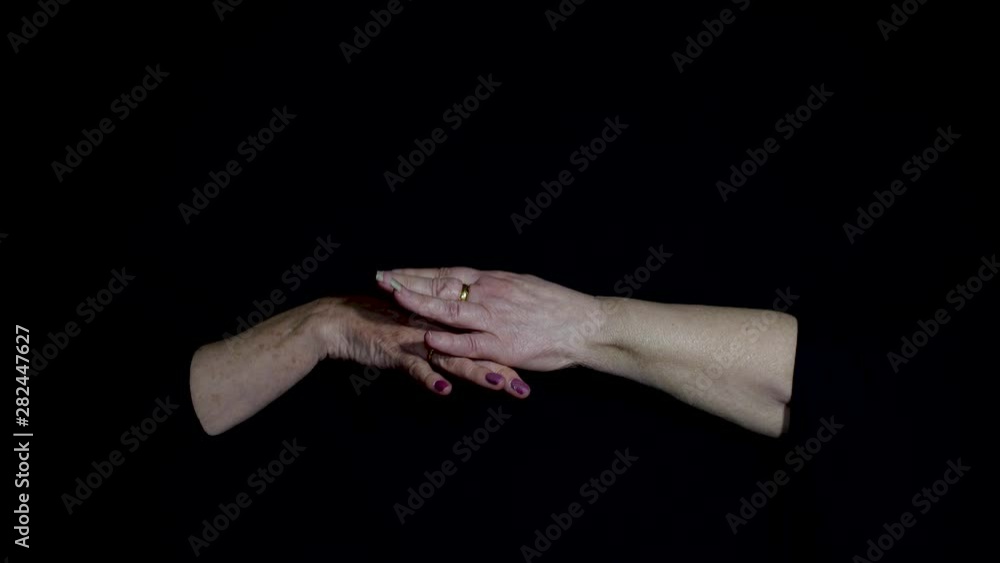 Video „A pair of diverse hands connecting in a spiritual way on dark ...
