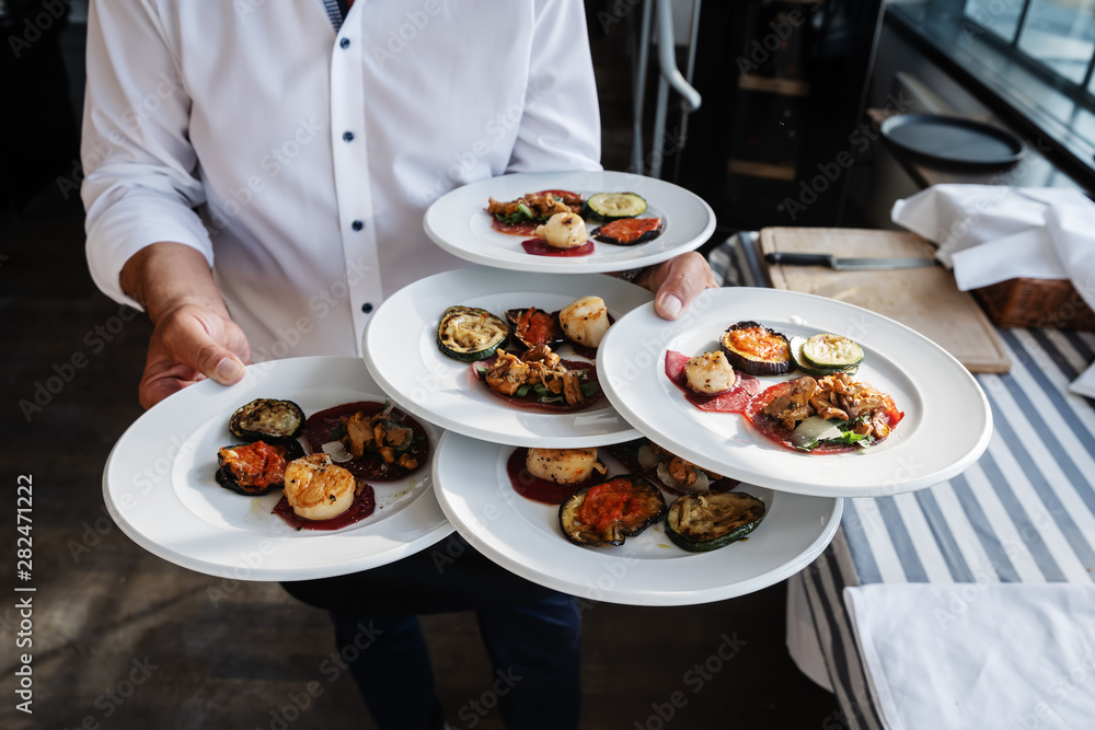 waiter serves Italian antipasti in an outdoor restaurant Stock Photo ...