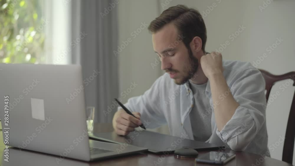 Video „Confident bearded man draws using graphic tablet looking into a ...