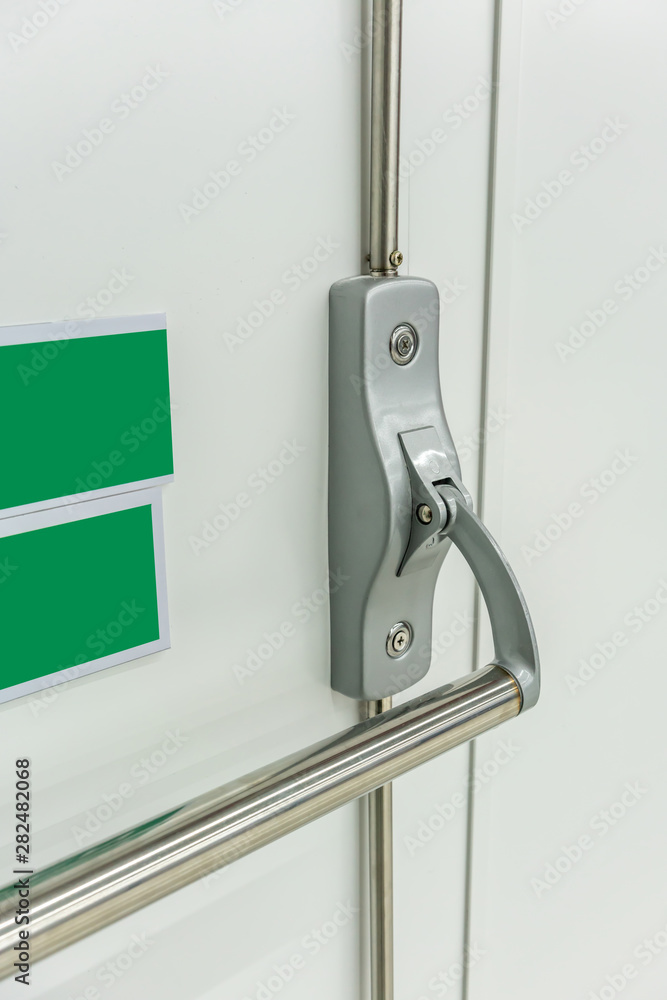 Closed up latch and door handle of emergency exit. Push bar and rail ...