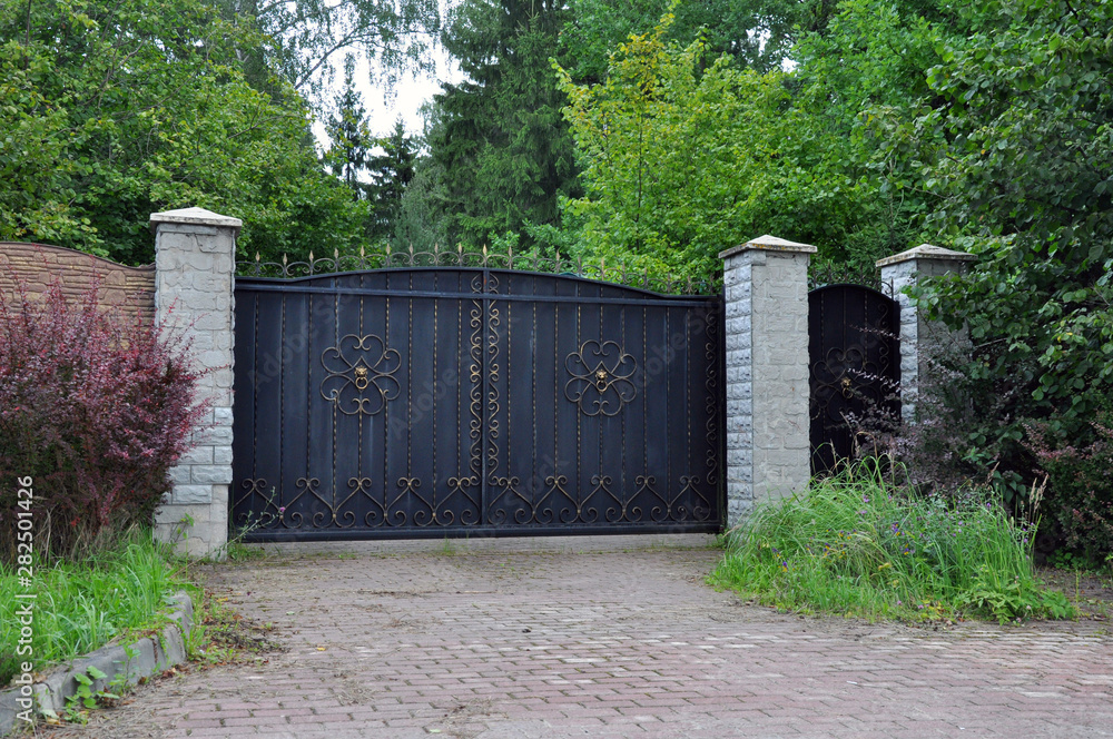 Iron front gate of a beautiful home. Stock Photo | Adobe Stock