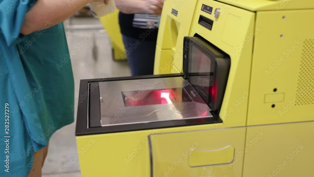 woman pays for purchases using a self-service machine with a touch ...