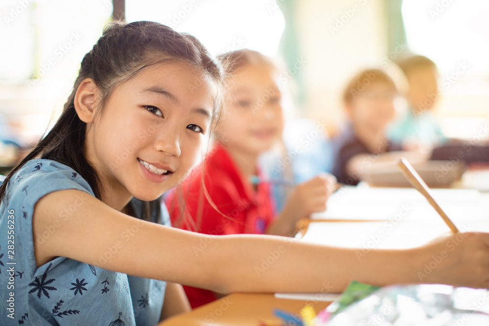 Smiling elementary school kids in classroom Stock Photo | Adobe Stock