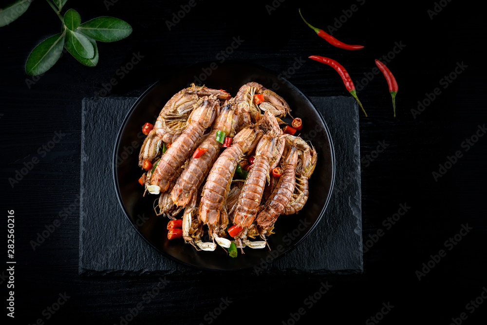 Mantis shrimp in pepper and salt shrimps in the black background Stock ...