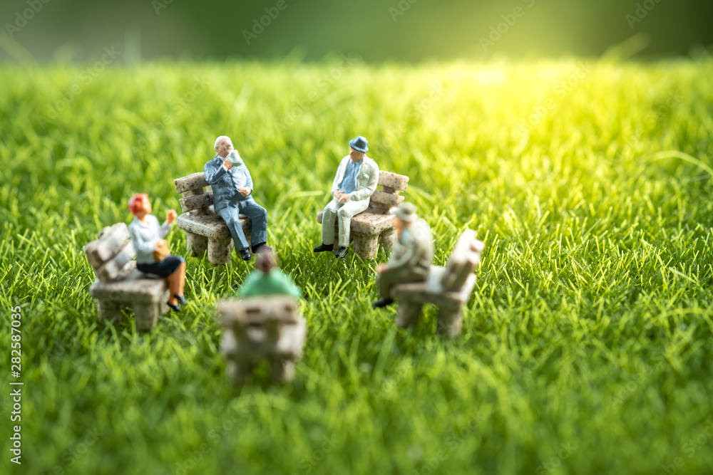 Miniature people: group of business people sitting in a garden, doing ...