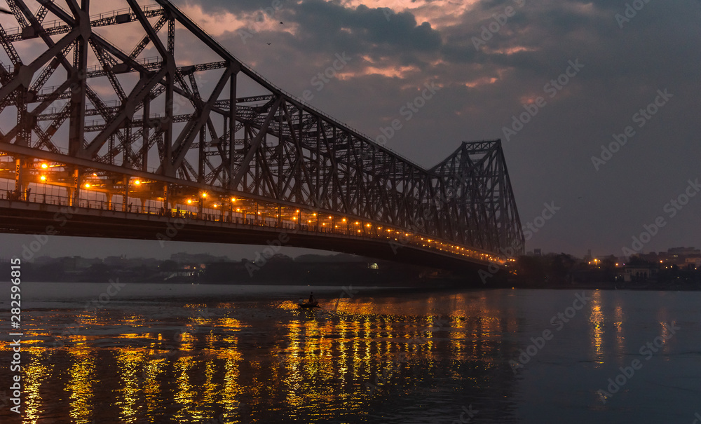 Silhouette of Howrah Bridge at the time of Sunrise. Howrah Bridge is a ...