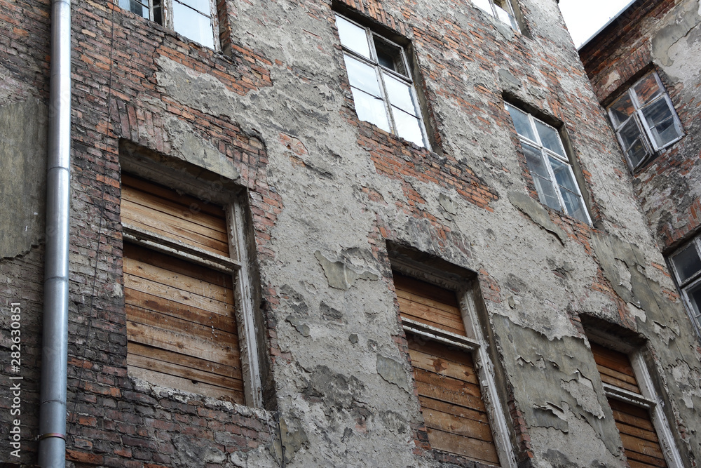 Courtyard of an old slum house with damaged brick walls in a poor and ...