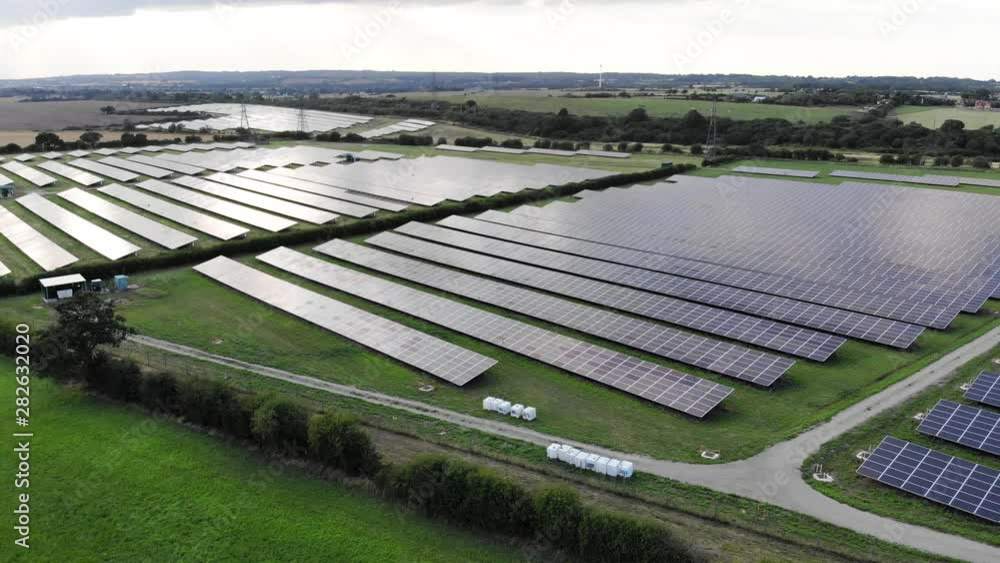 Aerial view of a solar farm with sunrays reflecting on the solar panels ...
