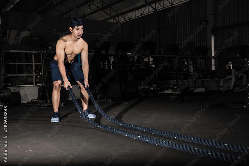 muscular men working out with battle ropes at gym . Battle ropes ...
