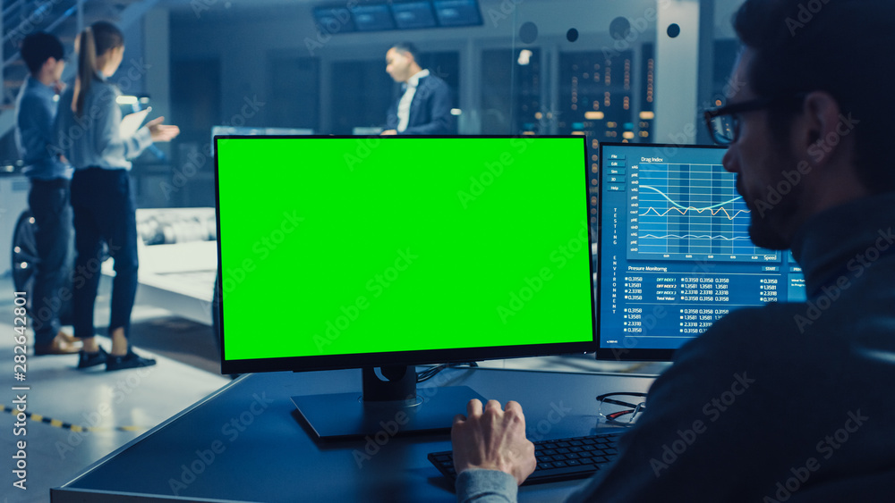 Professional Engineer Works on a Computer with Green Screen Mock Up and ...