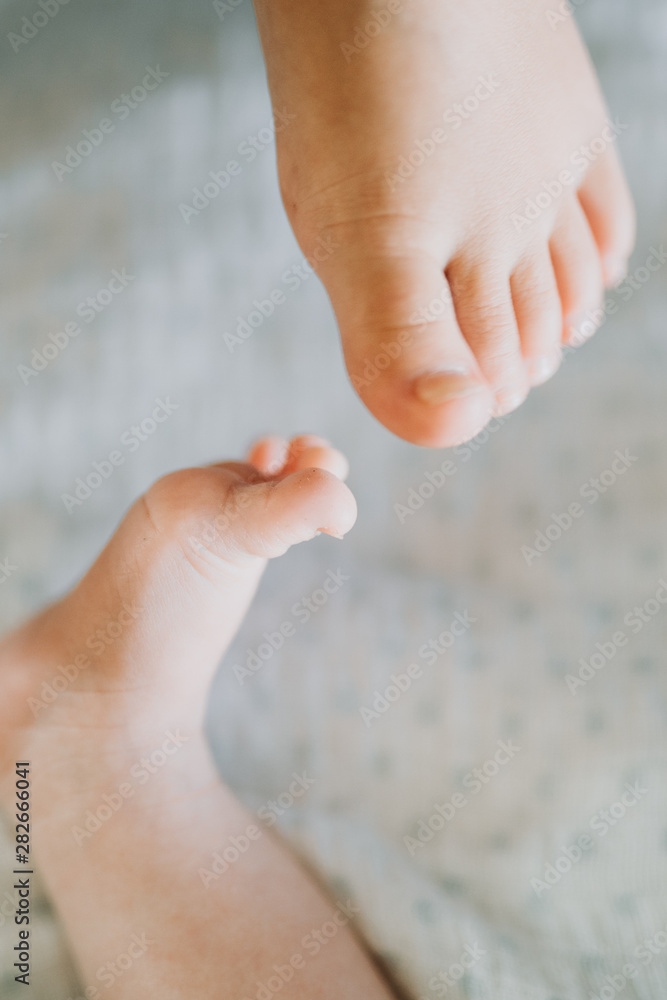 girl's feet and baby's feet touching Stock Photo | Adobe Stock