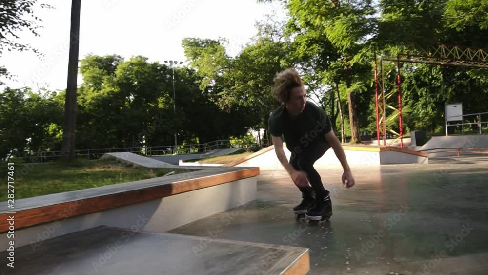 Aggressive In-Line skating in outdoor skatepark .Young athlete ride on ...