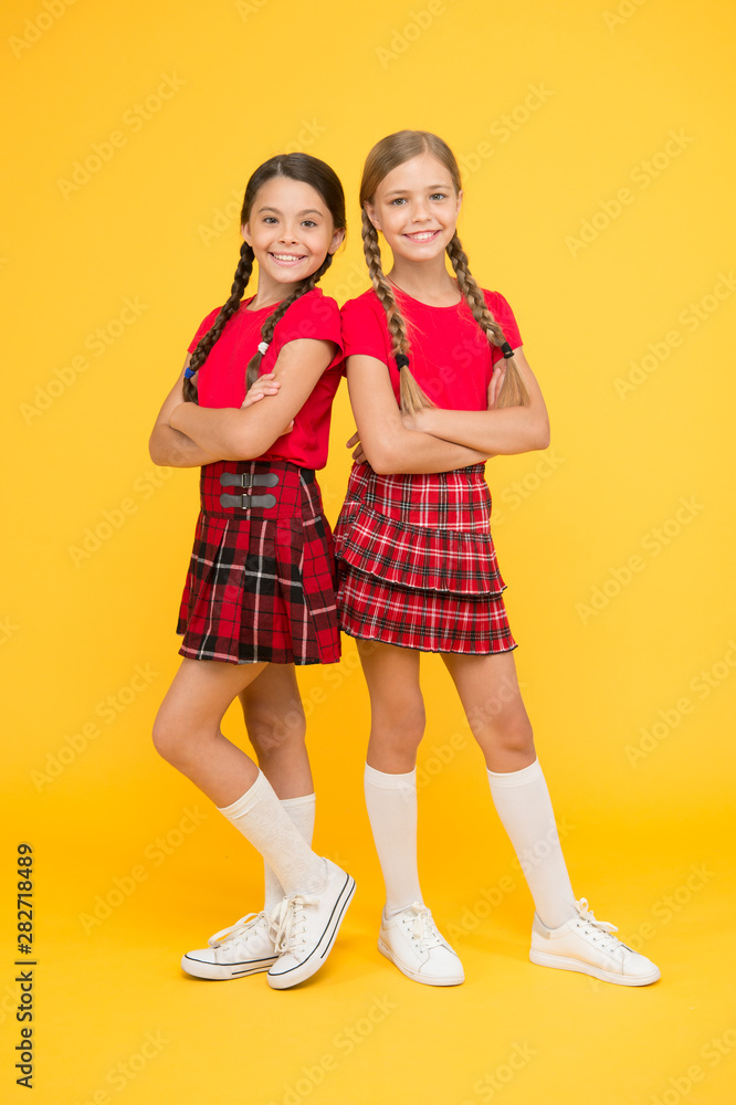 Playful kids. Happy small girls wearing same outfits. Friends enjoying ...